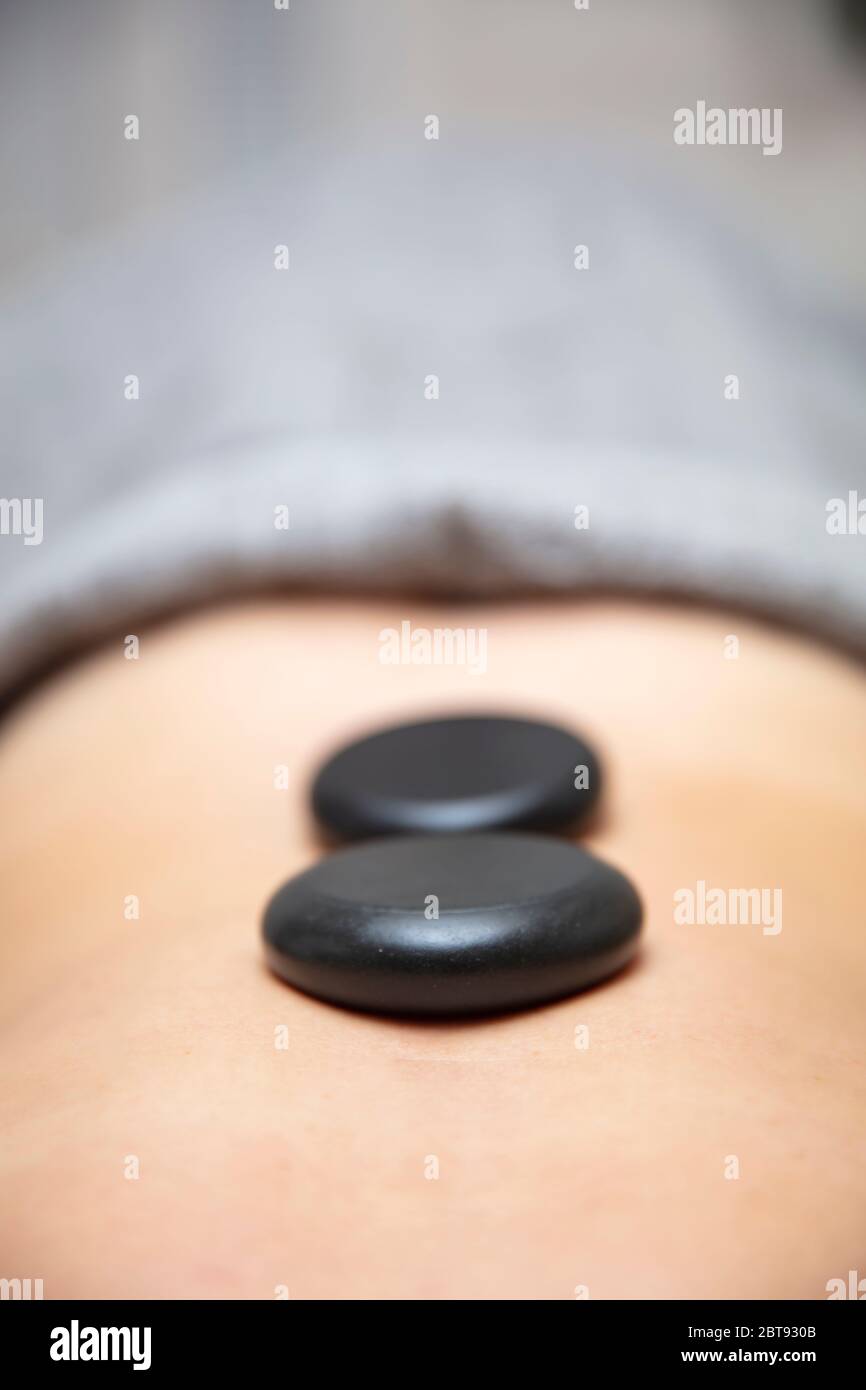 Young woman have a health spa relaxing stone therapy with hot volcanic ...