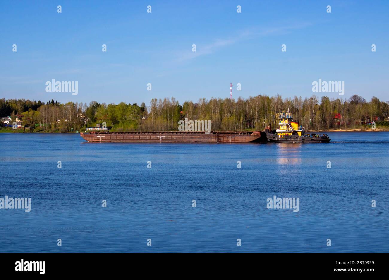 A tug pushing a heavy barge on the spring river Stock Photo - Alamy