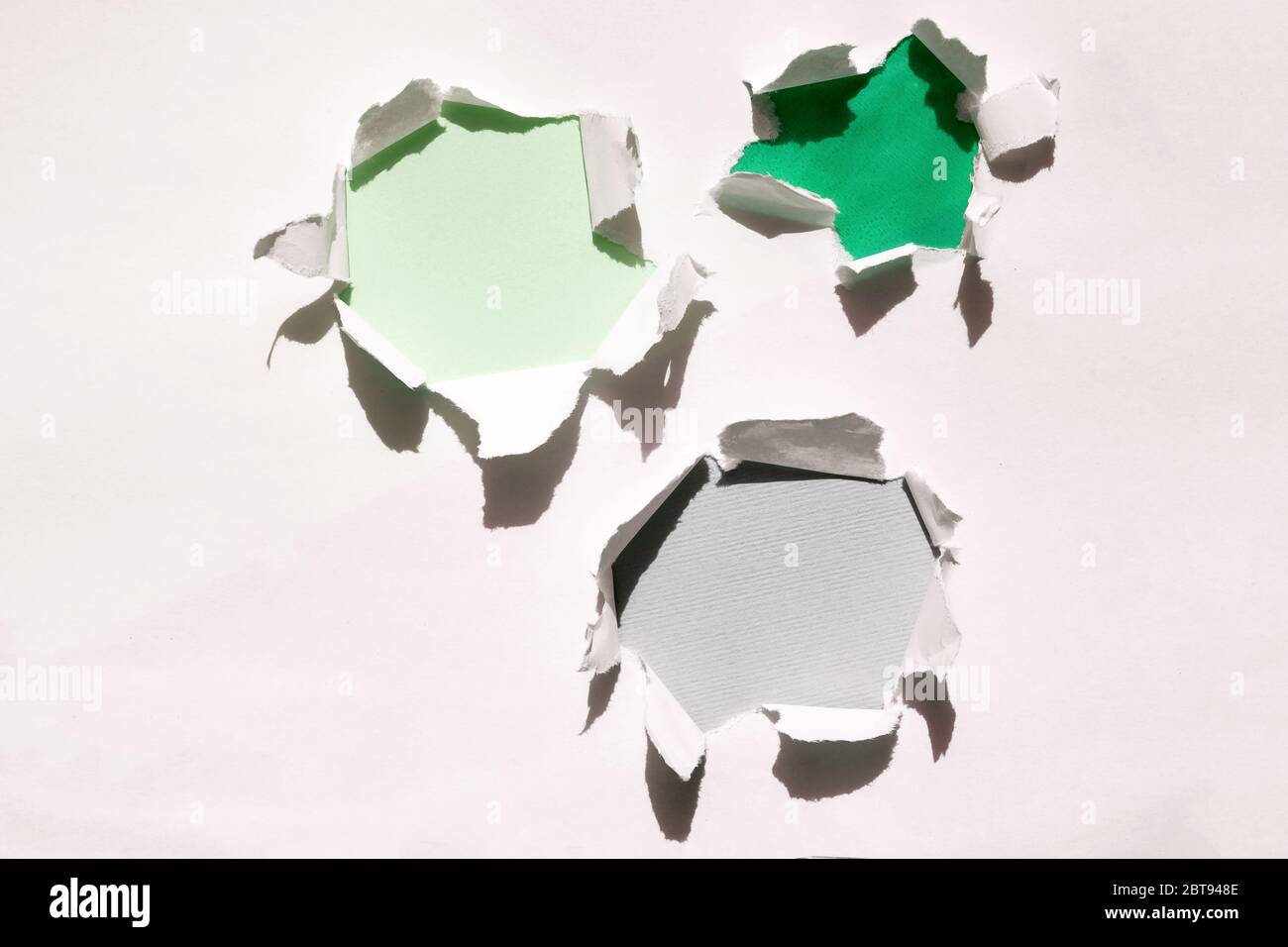 Holes in paper with different backgrounds top view. White paper with ...
