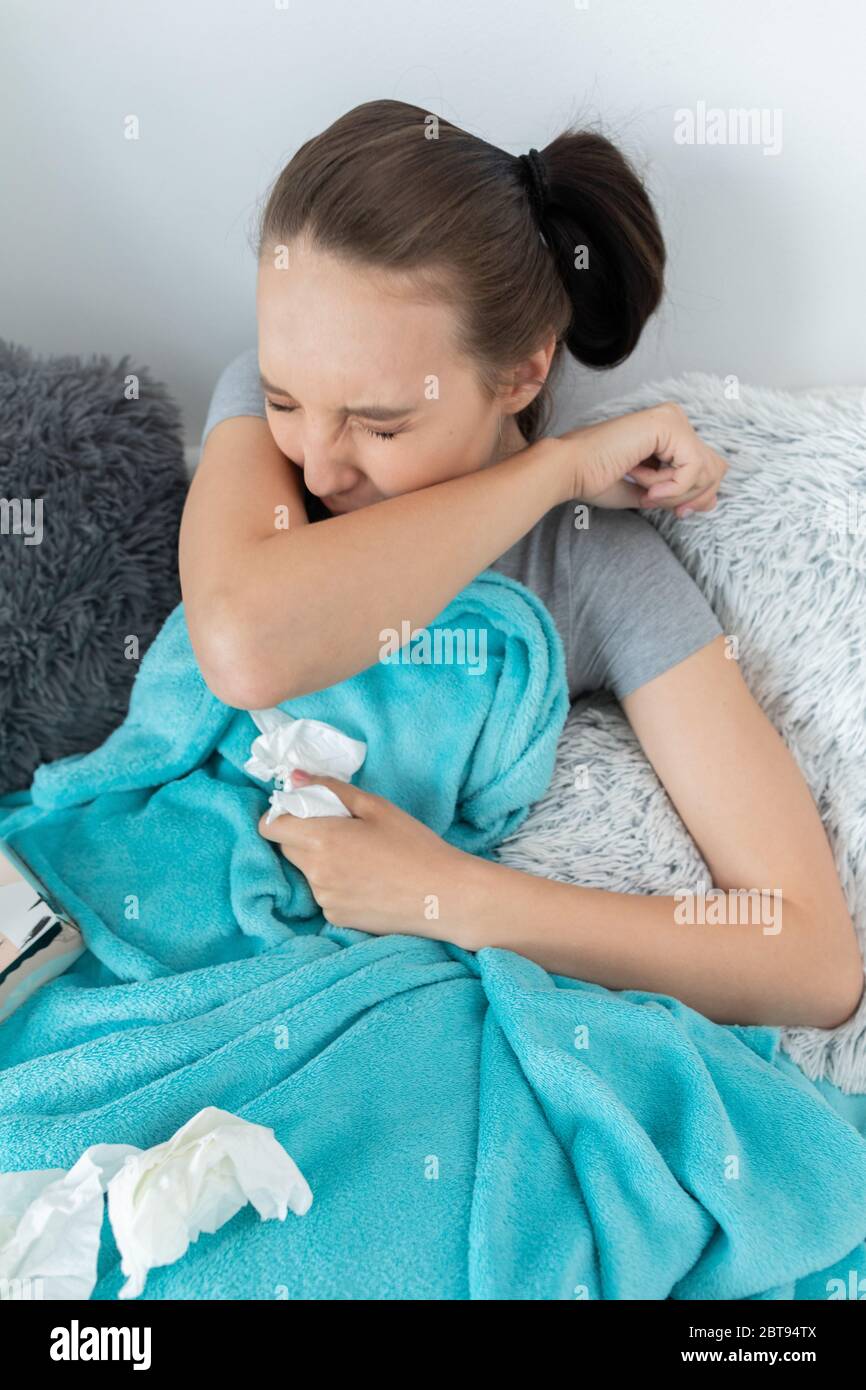 Strong cough on the elbow by a very cold young teenager who is lying in ...