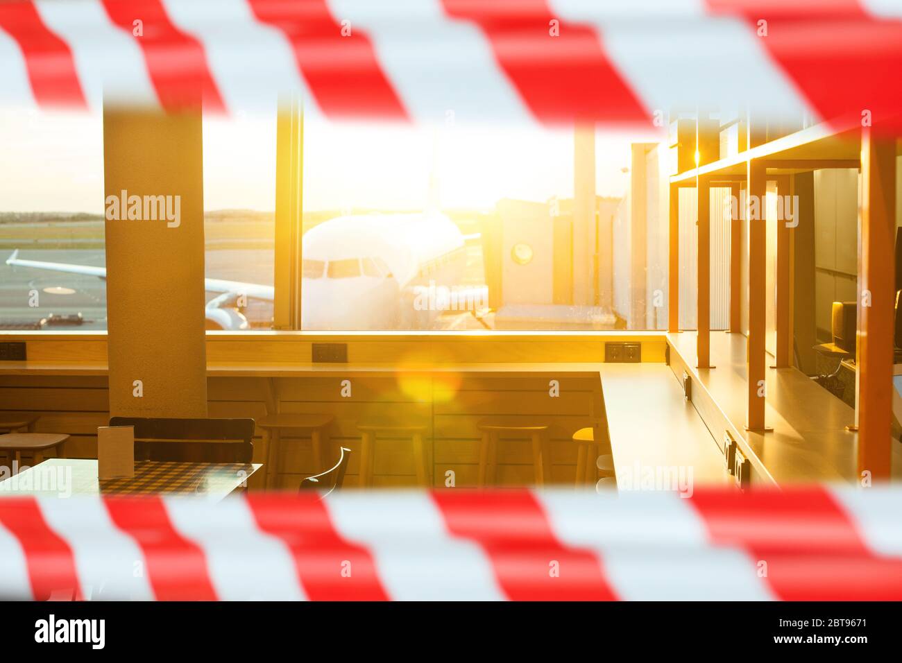 Airplane through airport window closed warning tape Stock Photo - Alamy