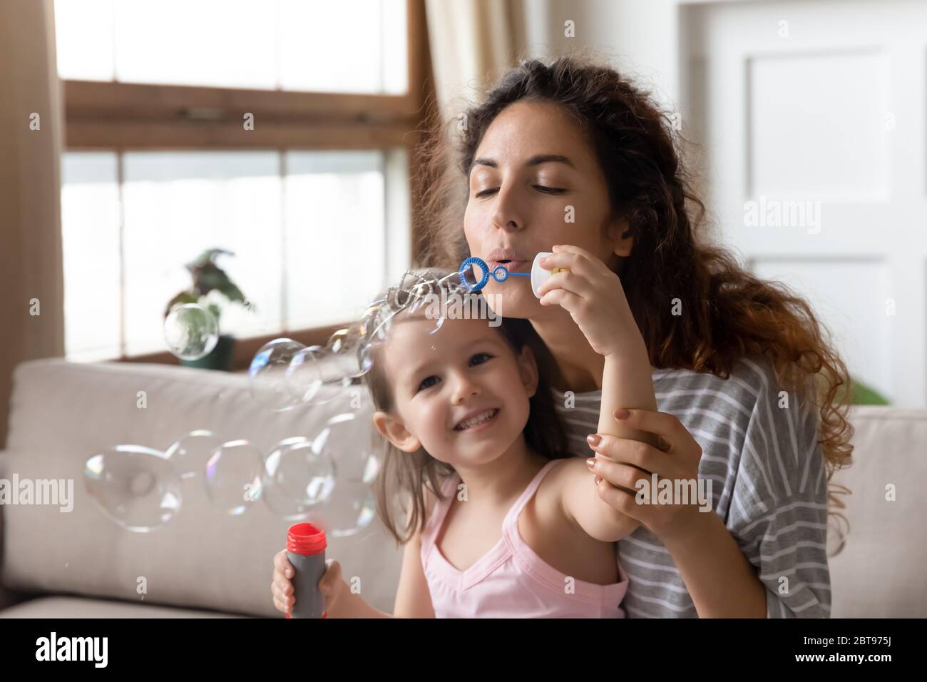 Little girl sitting blowing bubbles hi-res stock photography and images ...