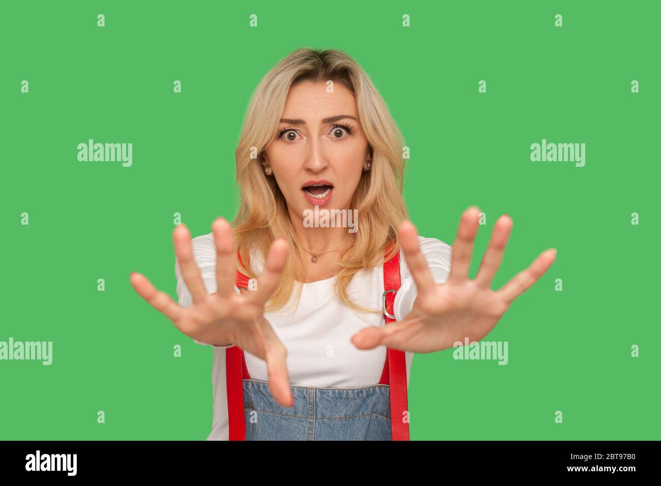 No, I'm afraid! Portrait of frightened shocked adult woman in overalls ...