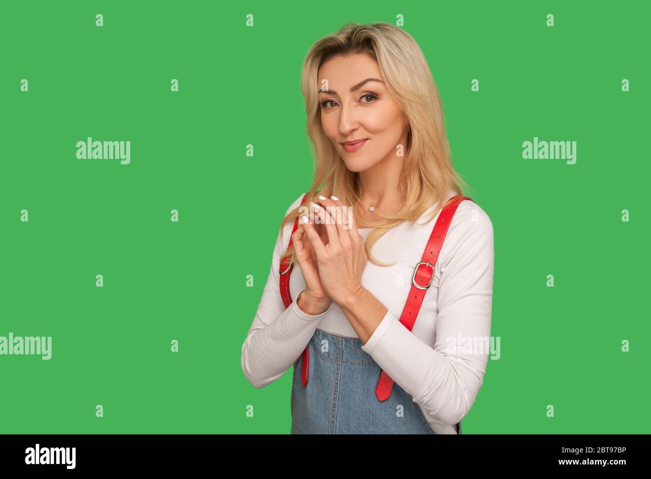 Portrait of sneaky scheming beautiful adult woman in stylish overalls ...