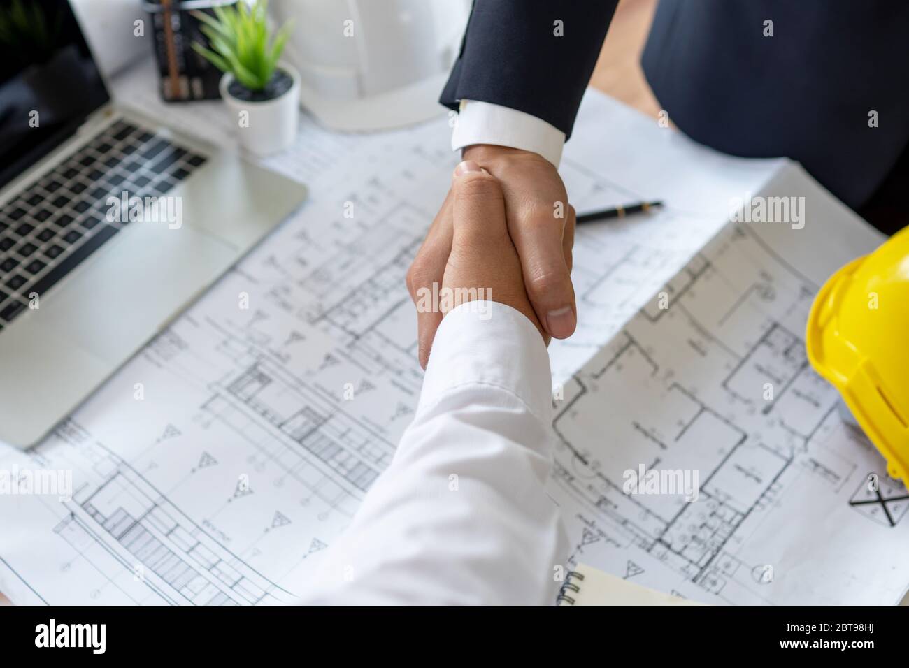 Handshake of two business man, after architect working and planning ...