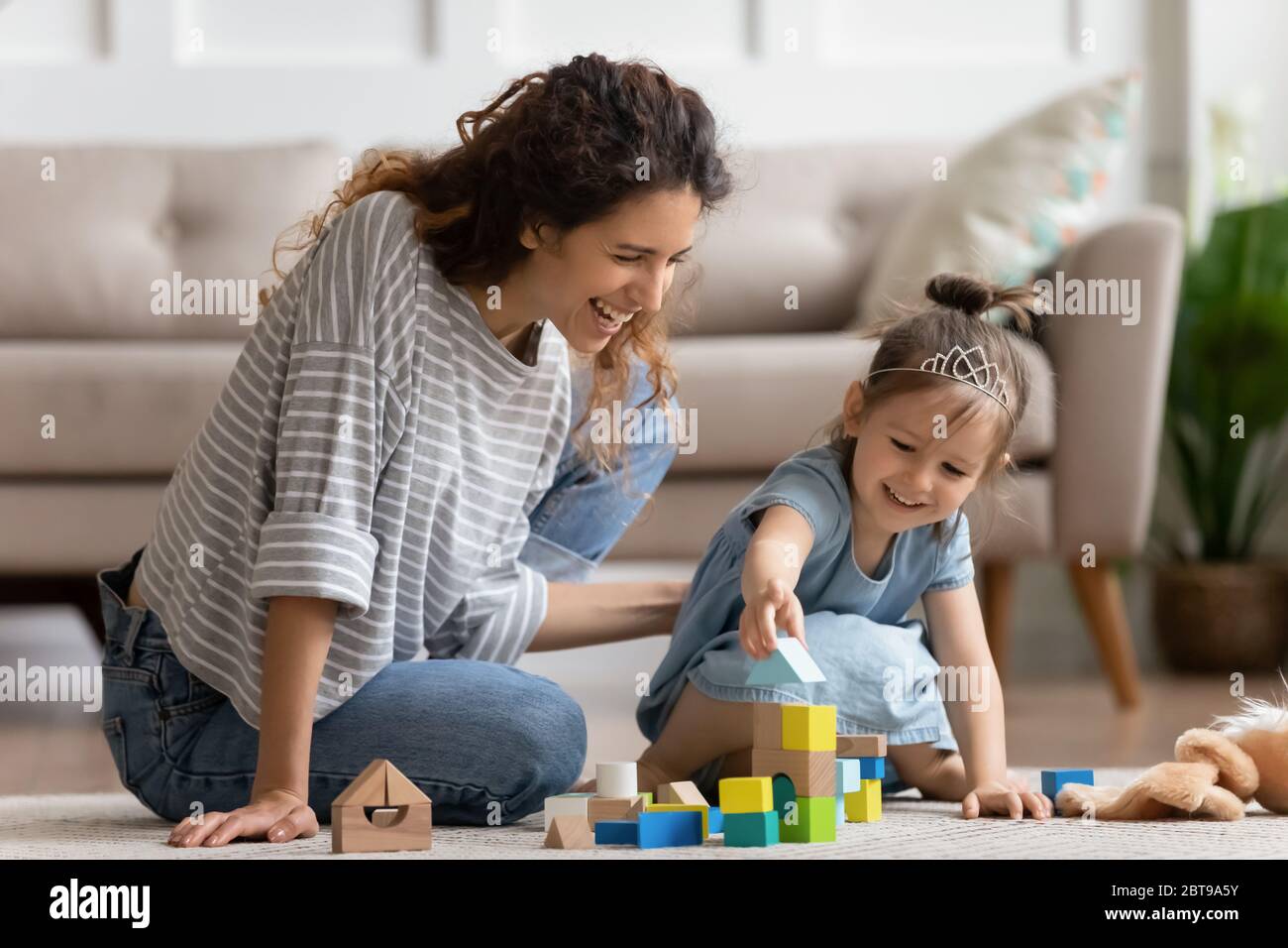 Laughing mother and little daughter playing colorful wooden blocks Stock Photo - Alamy