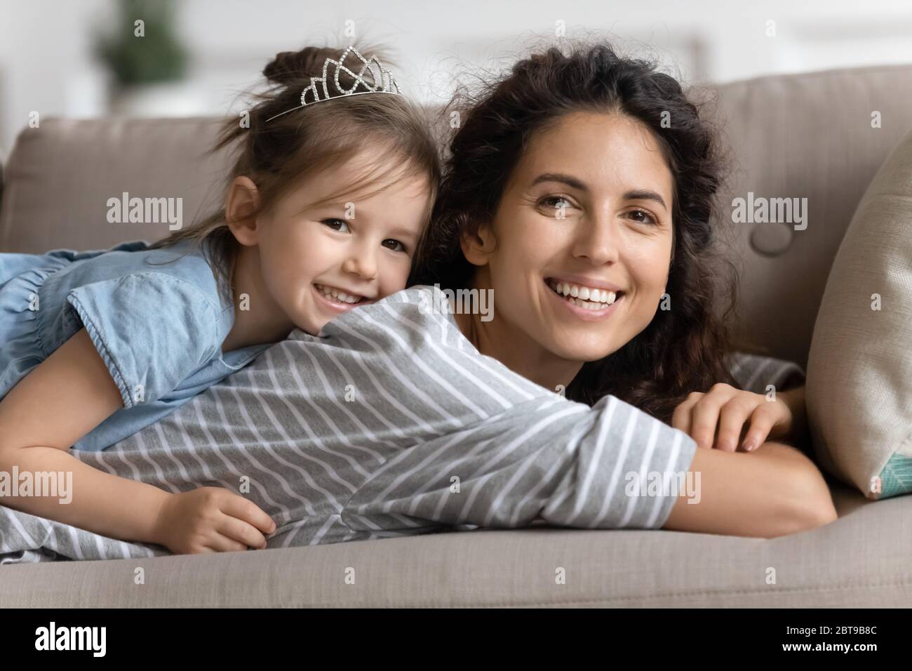 Head shot portrait cute girl lying on happy mother back Stock Photo - Alamy