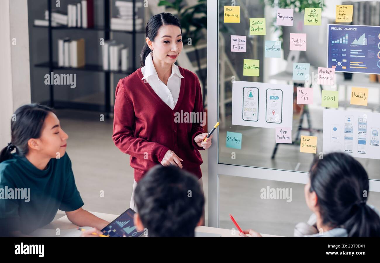 Asian Ux Developer And Ui Designer Presenting Mobile App Interface