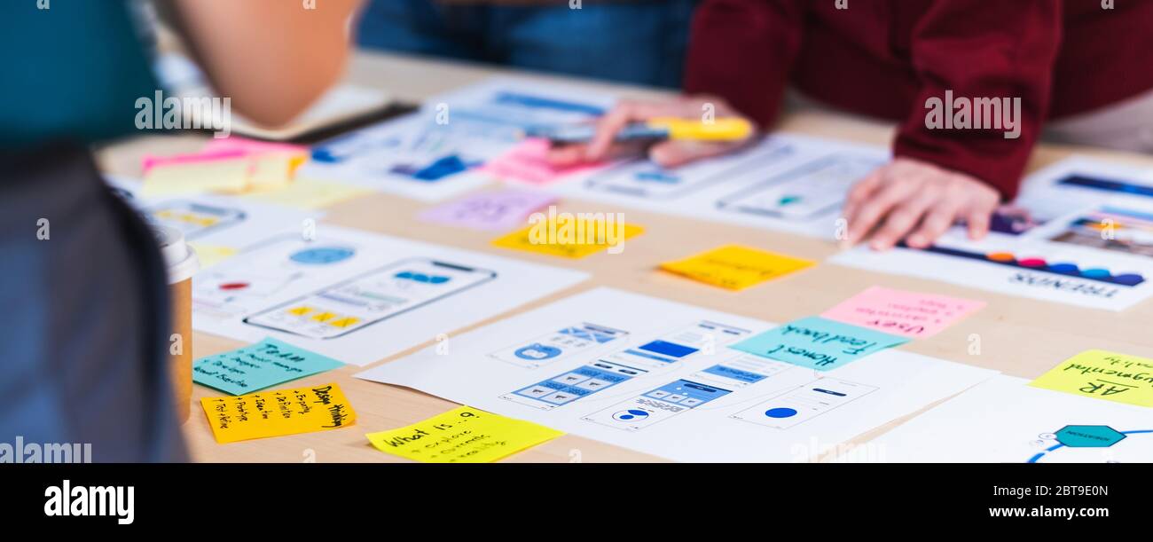 Close up ux developer and ui designer brainstorming about mobile app ...