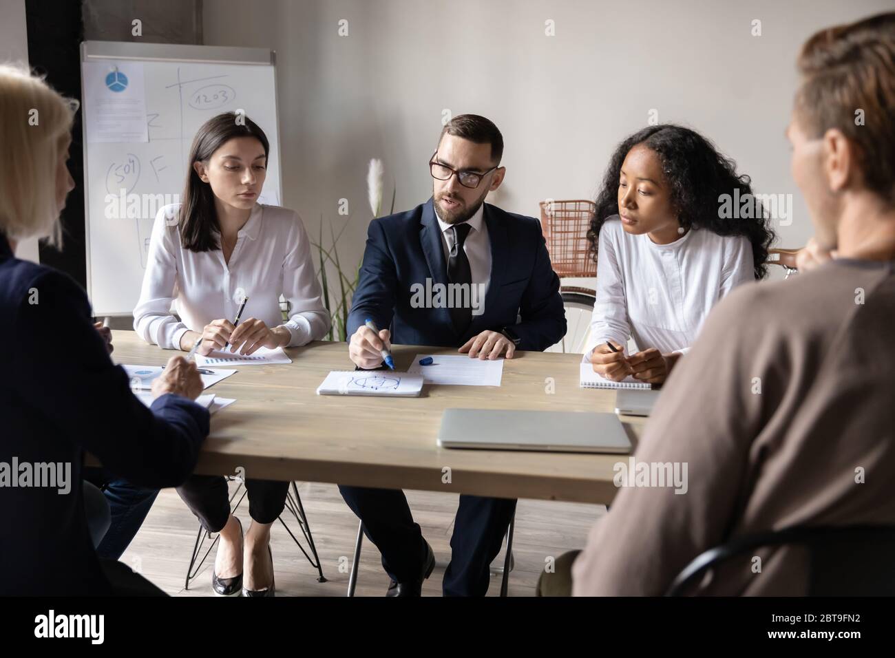 Diverse business partners discussing project strategy at group ...