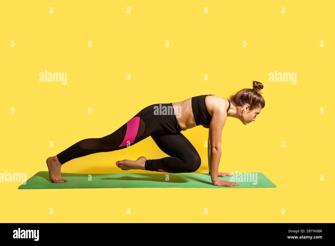 Assertive Motivated Fitness Woman With Hair Bun In Tight Sportswear