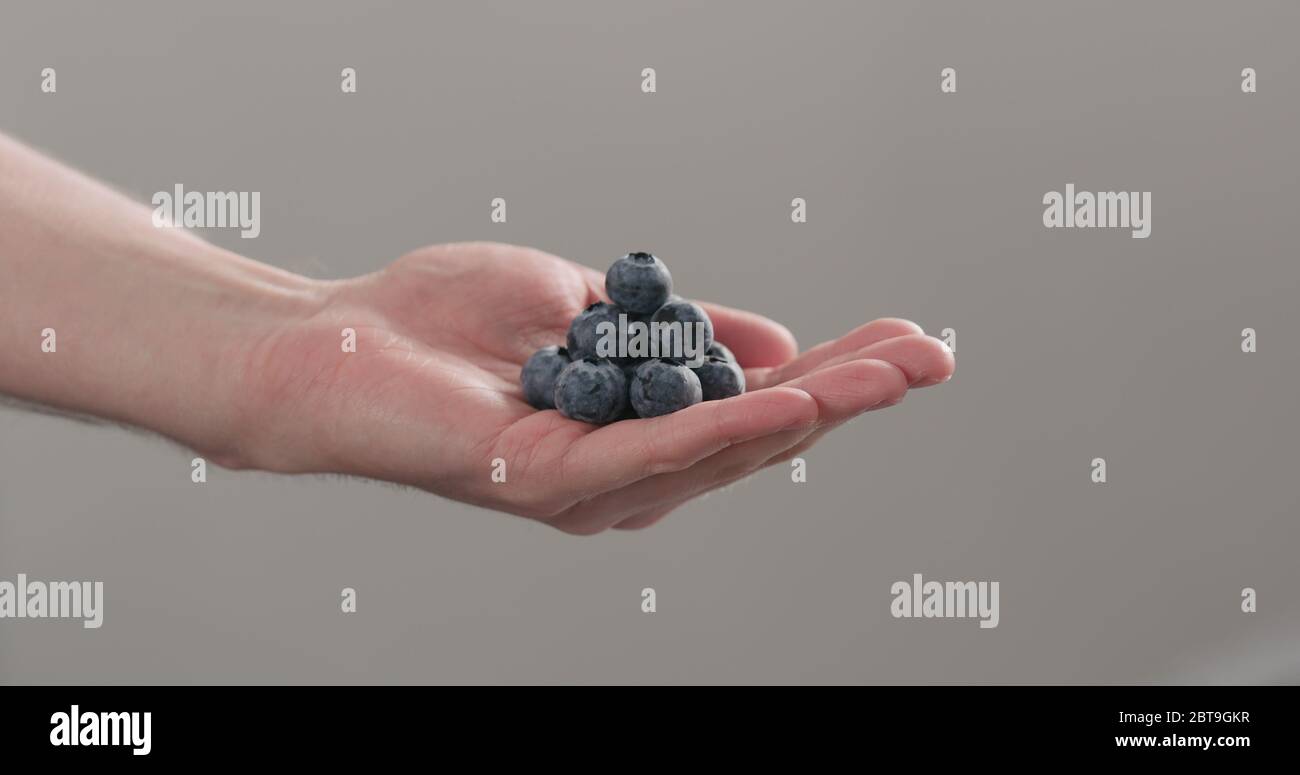 man hand show big ripe blueberries on neutral background Stock Photo ...
