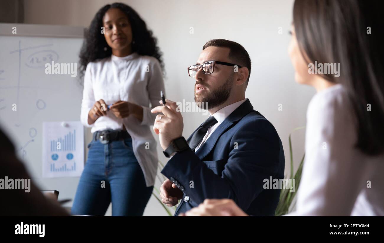 Confident businessman speaking at corporate meeting with business coach ...