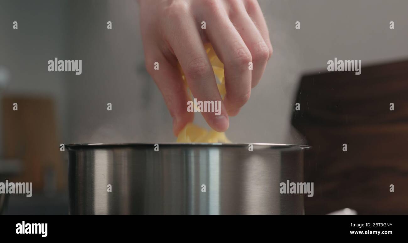 man hand put fettuccine pasta in saucepan with boiling water Stock ...