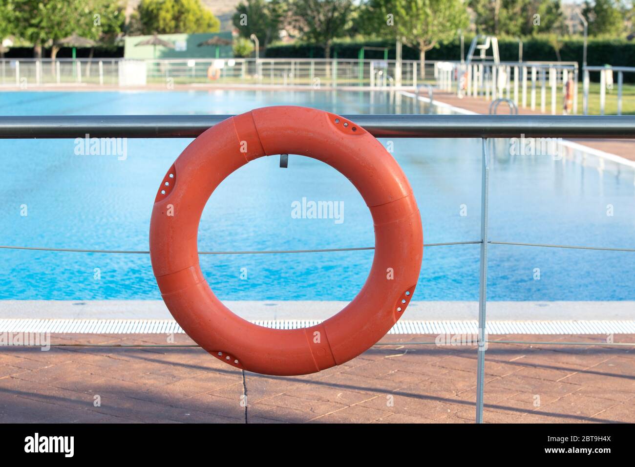 Orange lifebuoy floating on the surface of blue water in a pool Stock ...