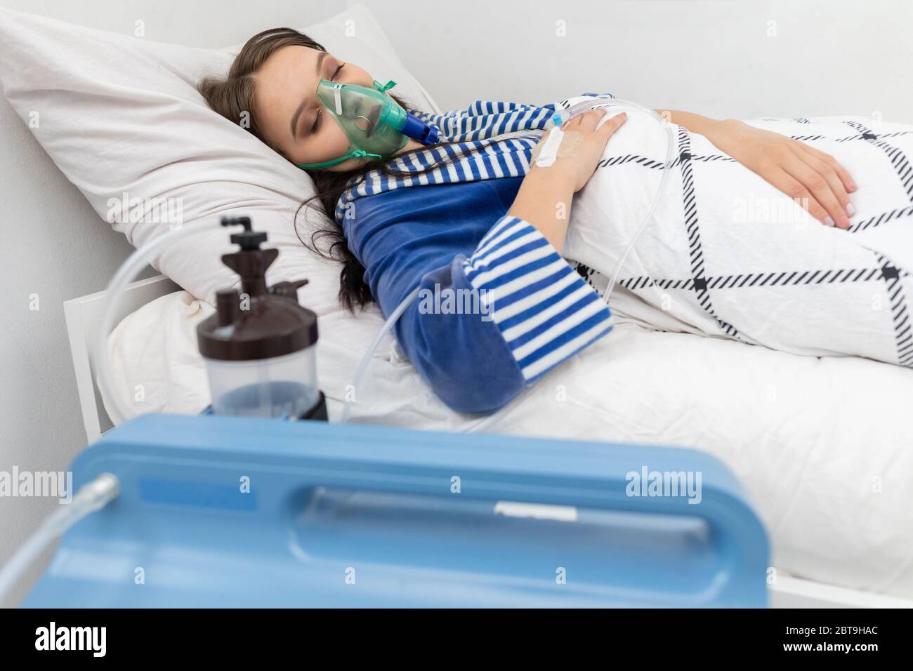 The teenager is wearing an oxygen supply mask. Medical ventilator ...