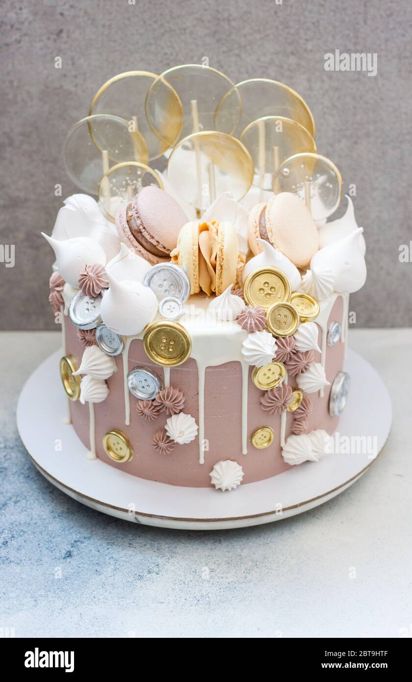 Light brown and golden colored birhtday cake with macaroons, coins ...