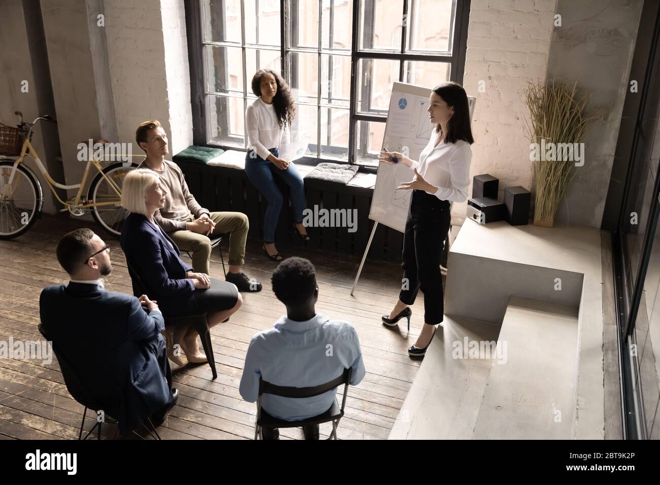Top view young business coach presenting statistics on flip chart Stock ...