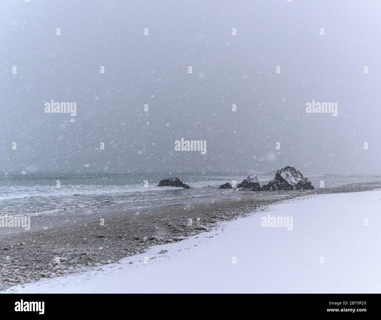 Beach along the Norwegian coast, covered with snow during a snowstorm ...