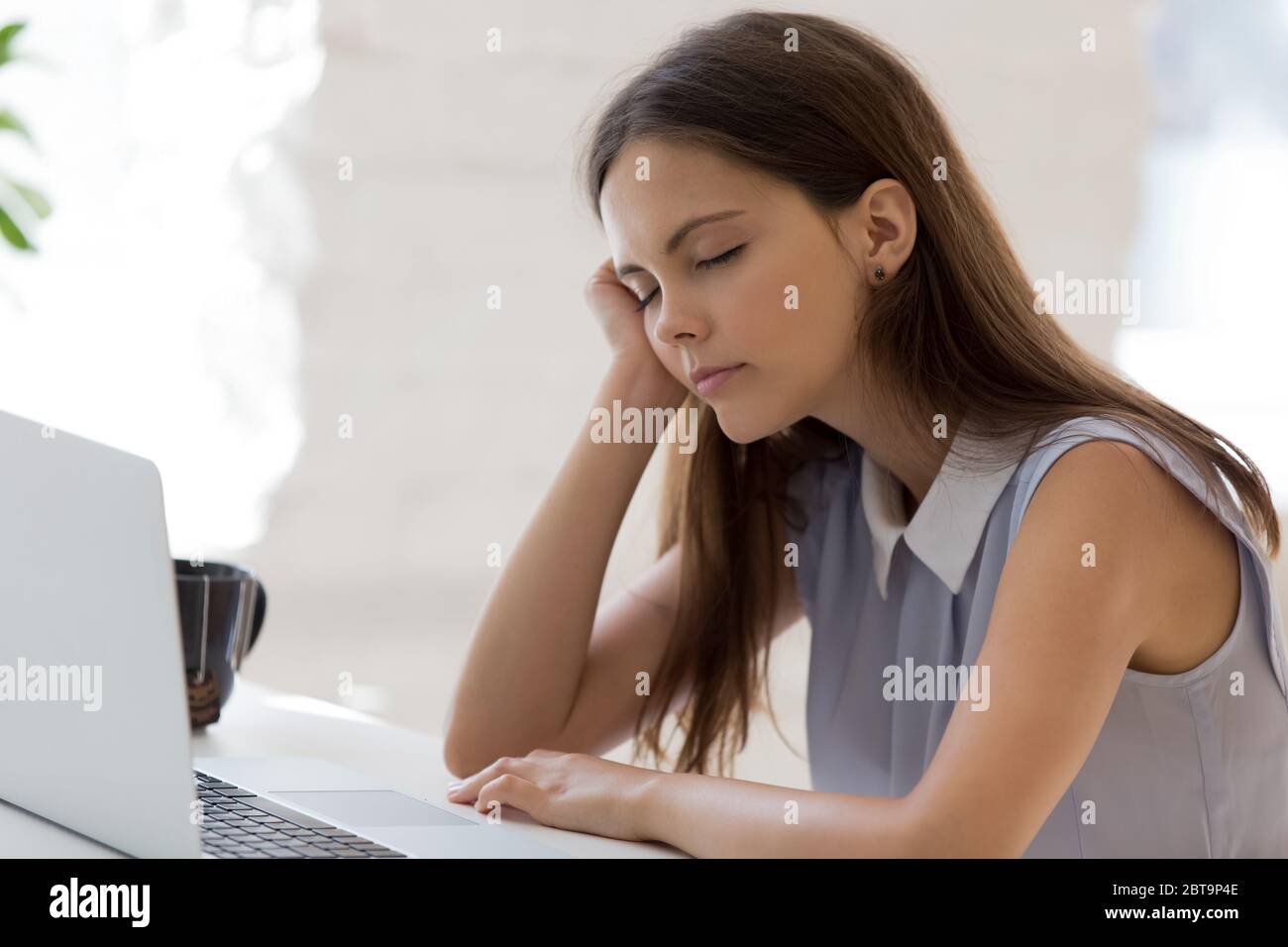 Exhausted young female fall asleep at workplace Stock Photo - Alamy