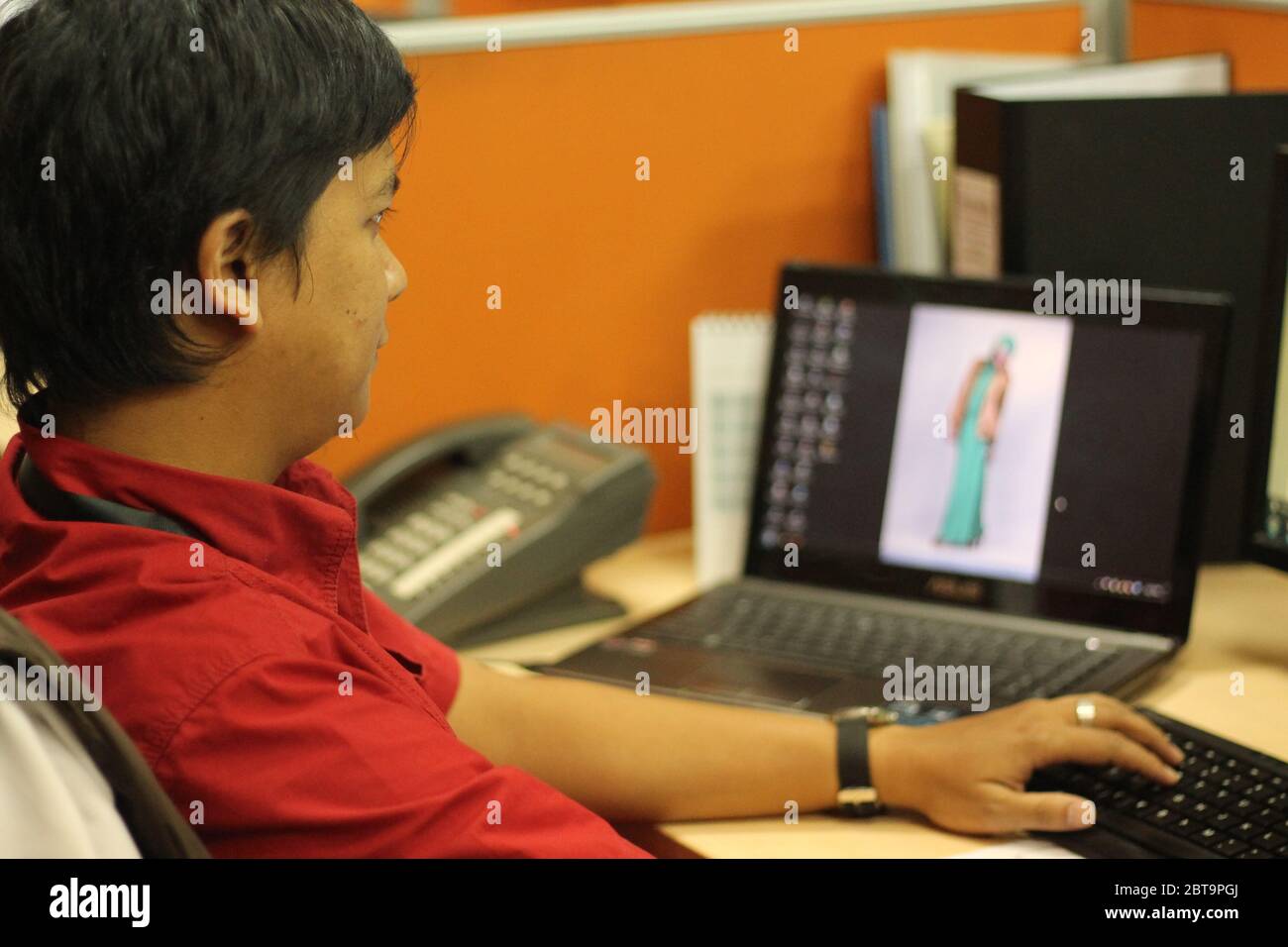 Office workers in a red shirts working in an office in orange cluster ...