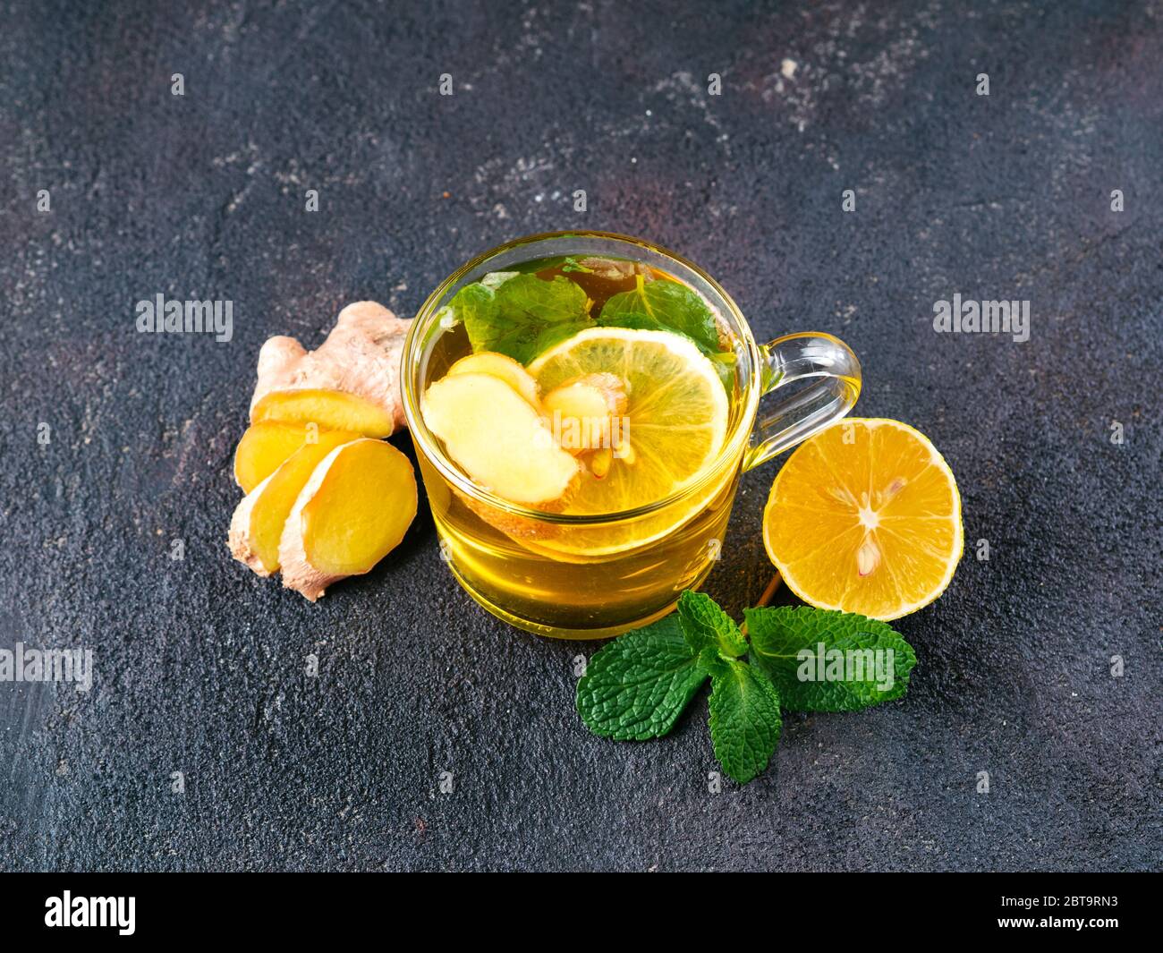 Herbal tea with ginger, mint and lemon. Tea glass cup and ingredients ...
