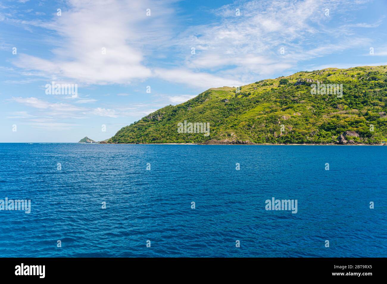 Deep blue sea in front of a lush green island with hills on it. Yasawa ...