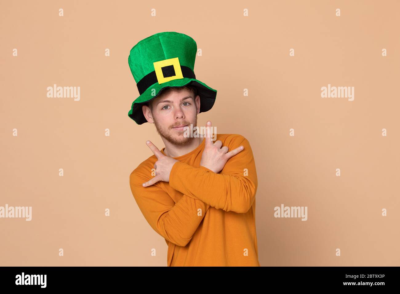 Attractive young guy with a big green hat on a yellow background Stock ...