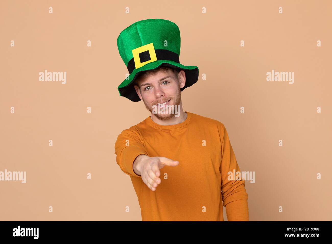 Attractive young guy with a big green hat on a yellow background Stock ...