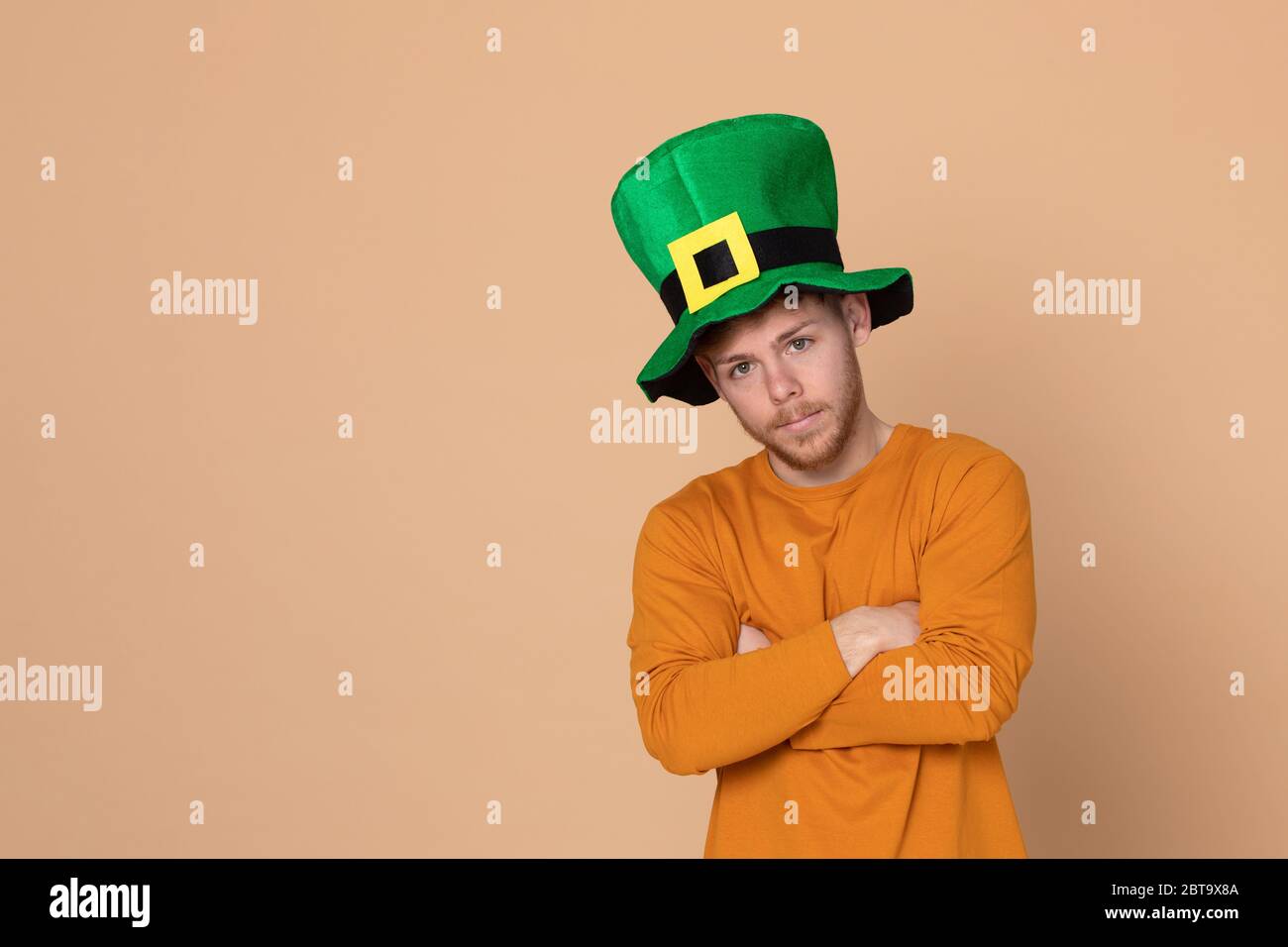 Attractive young guy with a big green hat on a yellow background Stock ...