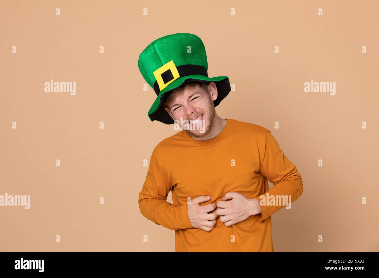 Attractive young guy with a big green hat on a yellow background Stock ...