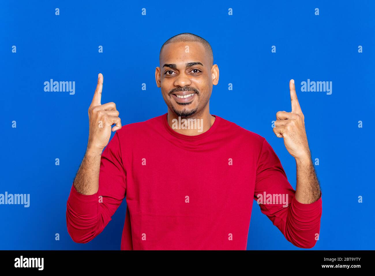 African man with red T-shirt on a blue background Stock Photo - Alamy