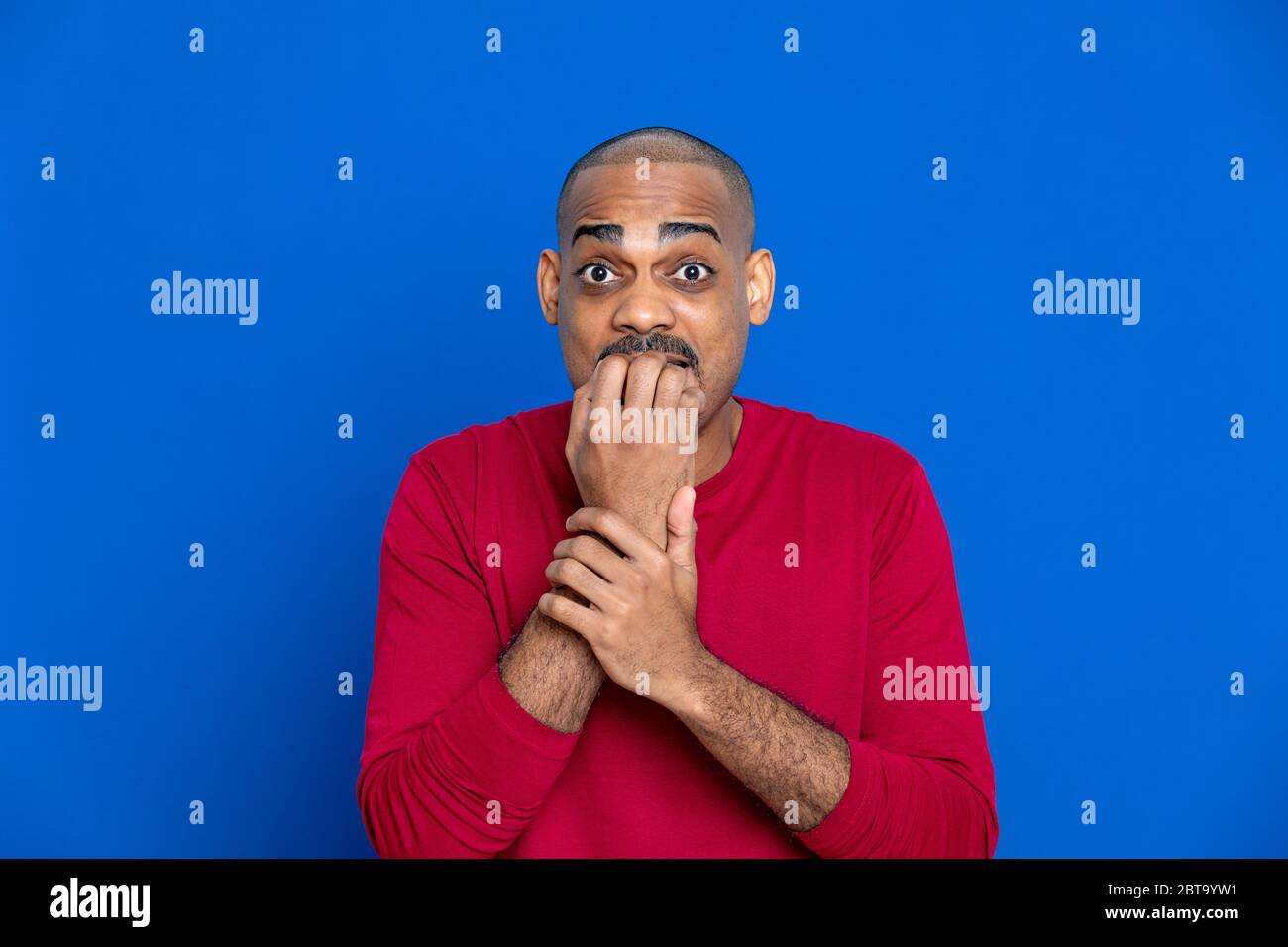 African man with red T-shirt on a blue background Stock Photo - Alamy