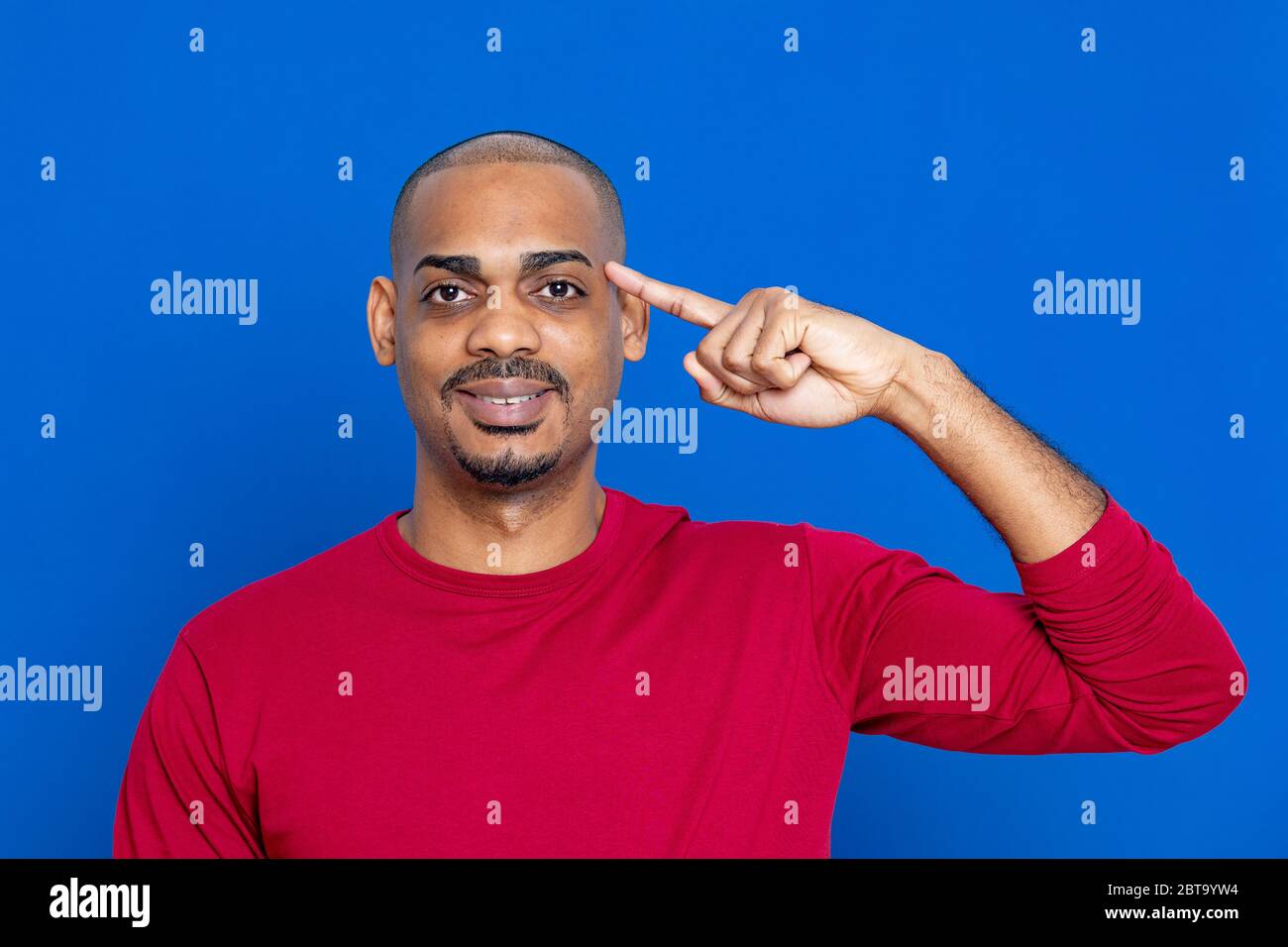 African man with red T-shirt on a blue background Stock Photo - Alamy