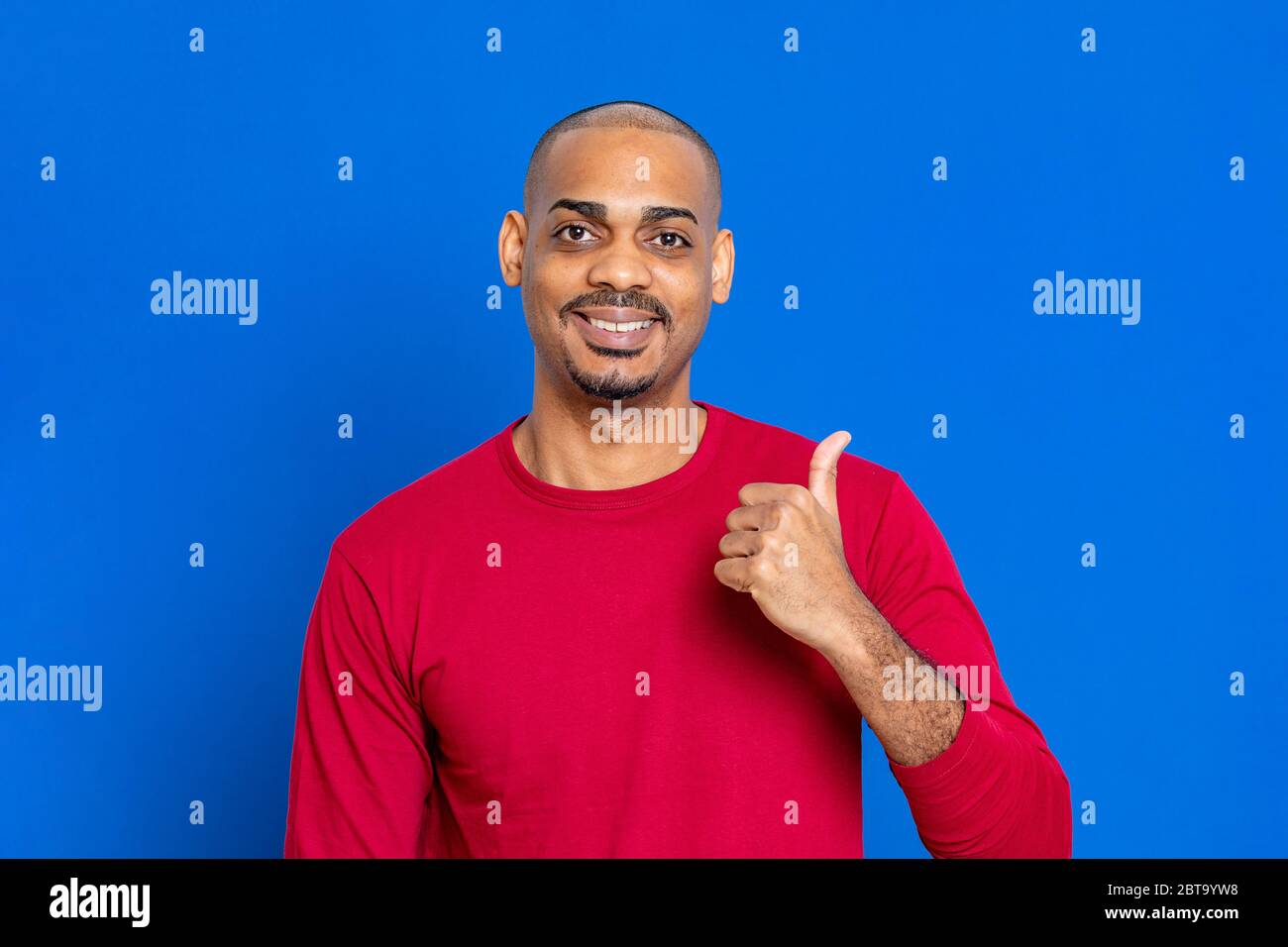 African man with red T-shirt on a blue background Stock Photo - Alamy