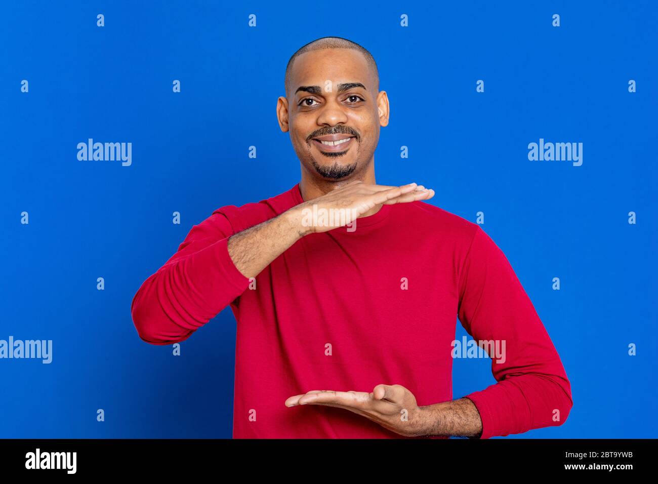 African man with red T-shirt on a blue background Stock Photo - Alamy
