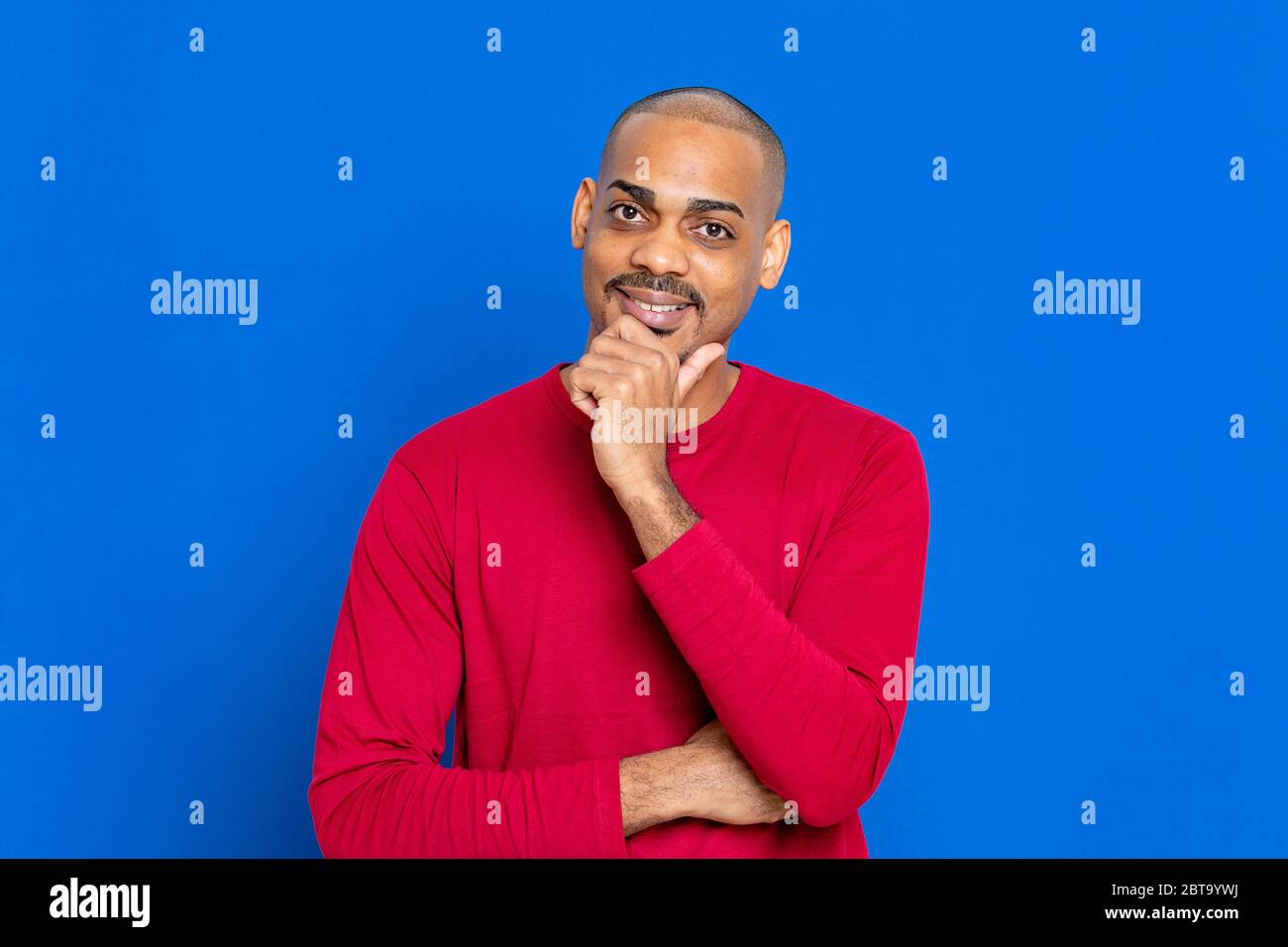 African man with red T-shirt on a blue background Stock Photo - Alamy