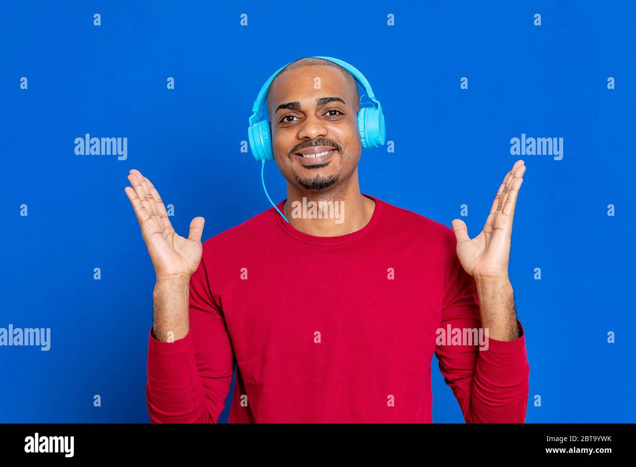 African man with red T-shirt on a blue background Stock Photo - Alamy