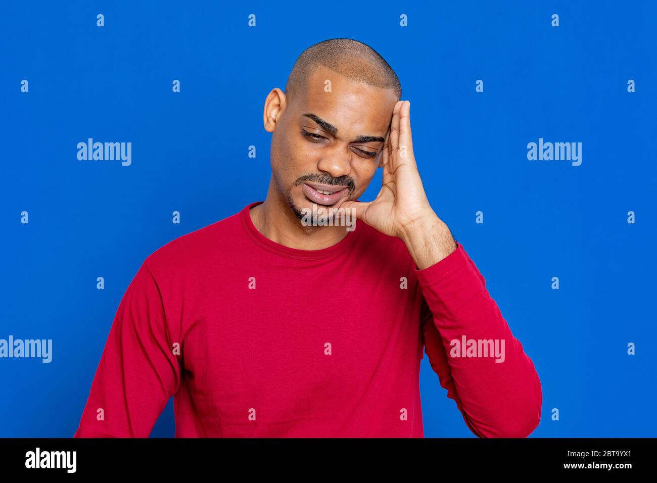 African man with red T-shirt on a blue background Stock Photo - Alamy