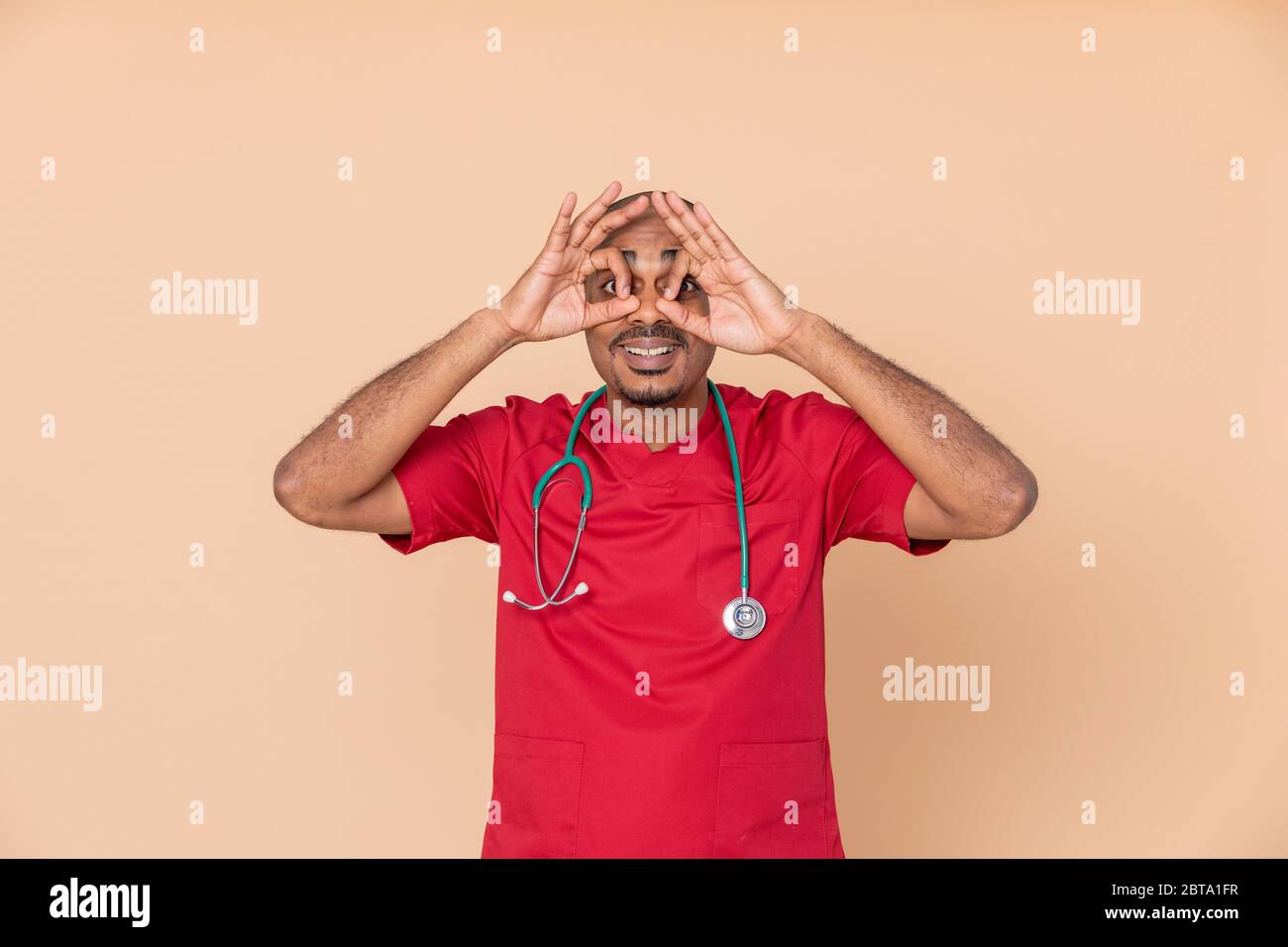African doctor wearing red uniform on a orange background Stock Photo ...