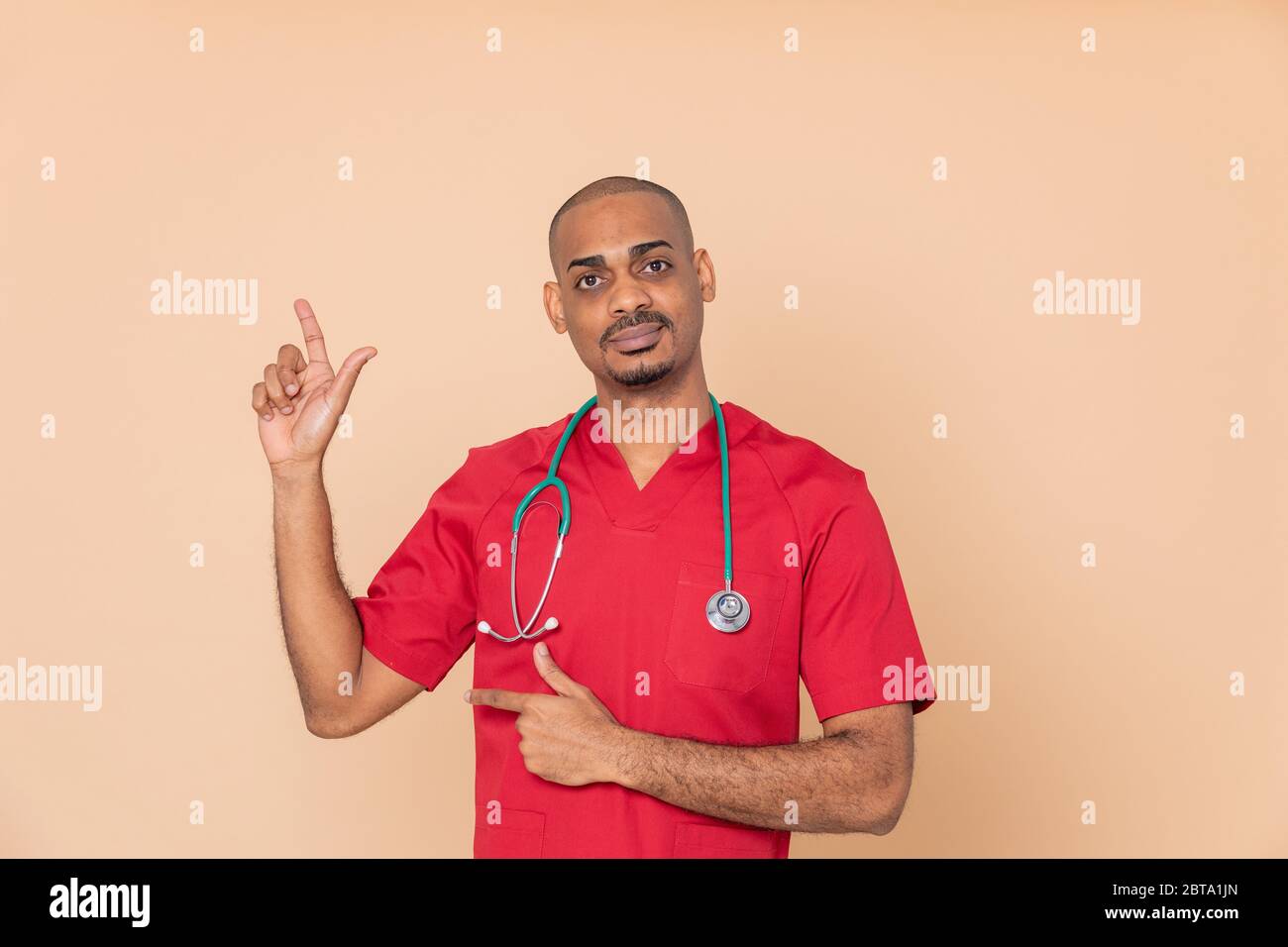 African doctor wearing red uniform on a orange background Stock Photo ...