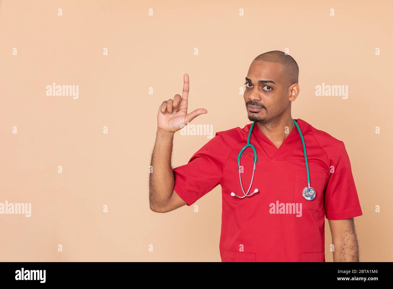 African doctor wearing red uniform on a orange background Stock Photo ...