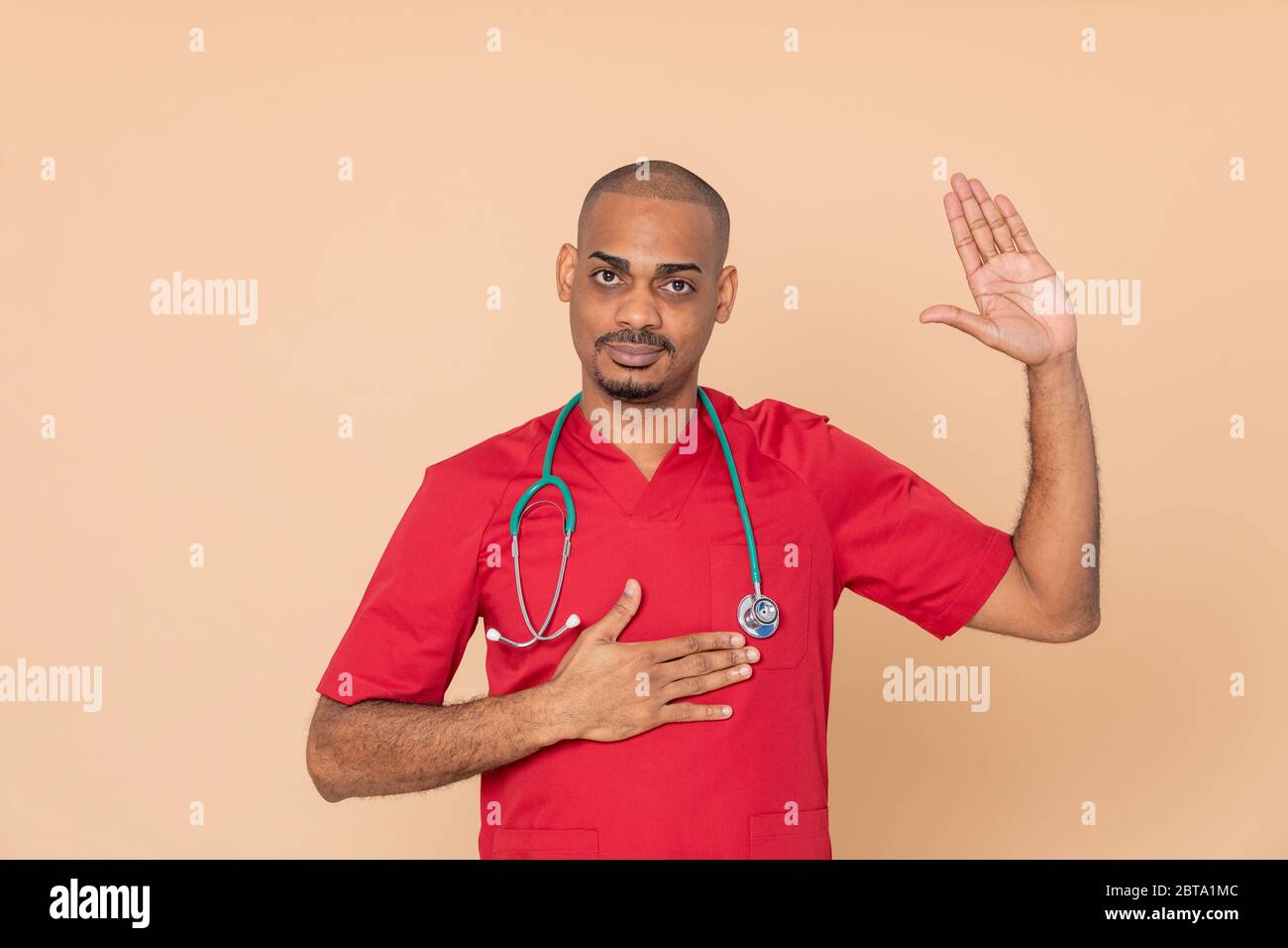 African doctor with red uniform on a yellow background Stock Photo - Alamy
