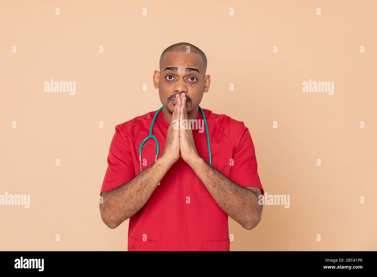 African doctor praying on a orange background Stock Photo - Alamy