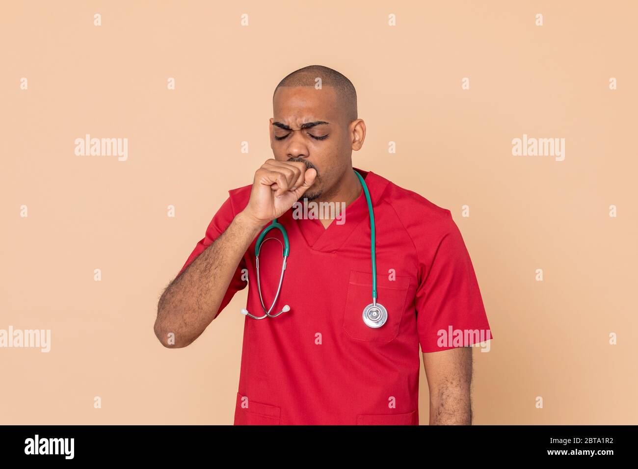 African doctor wearing a red uniform on a yellow background Stock Photo ...