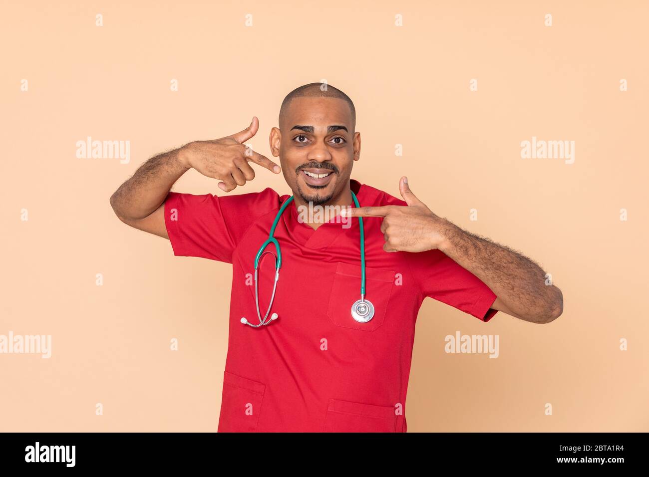 African doctor wearing a red uniform on a orange background Stock Photo ...