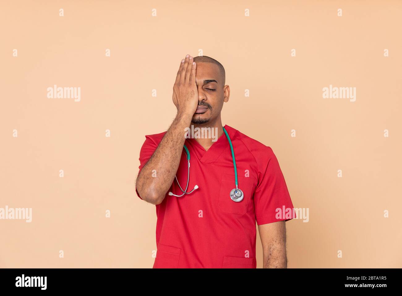African doctor wearing red uniform on a orange background Stock Photo ...
