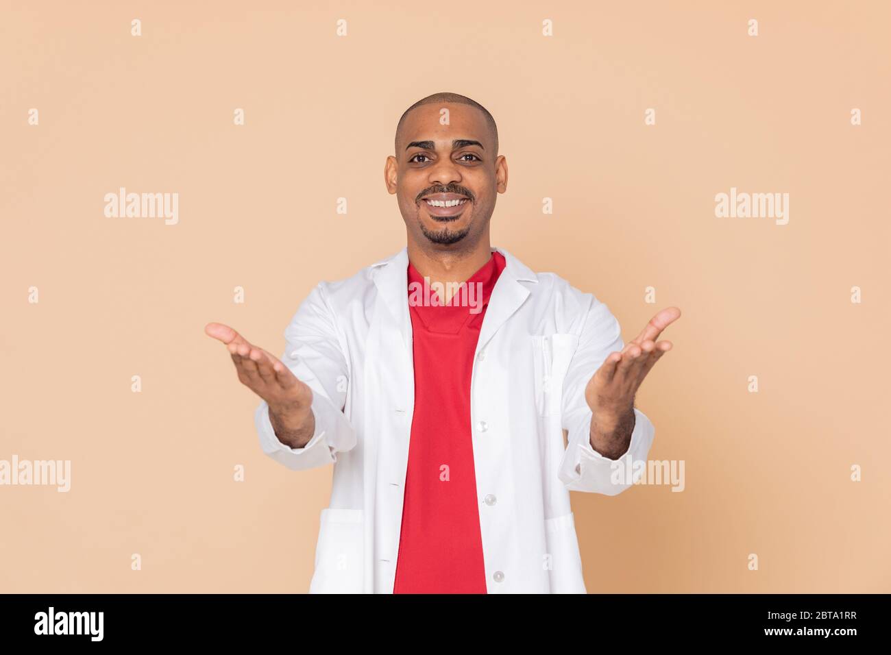 Friendly doctor wearing red uniform on a orange background Stock Photo ...