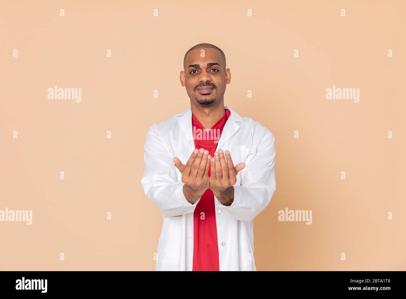 Friendly doctor wearing red uniform on a orange background Stock Photo ...