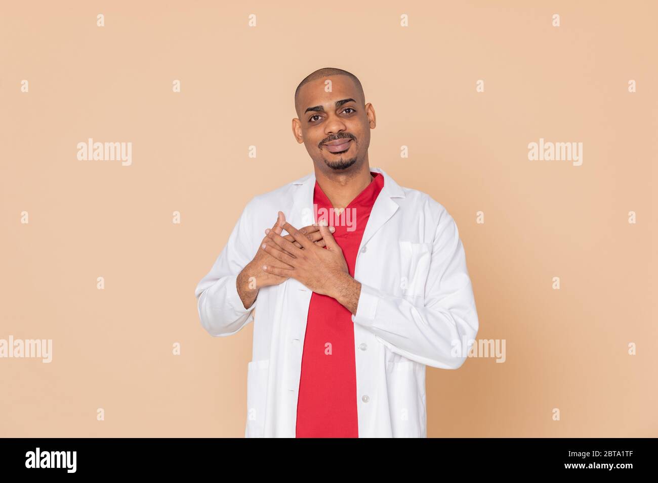 African doctor wid red uniform on a orange background Stock Photo - Alamy